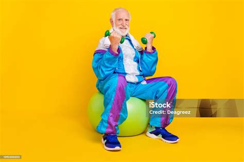 노란 색 배경 위에 고립 된 공 워밍업 정권에 앉아있는 은퇴 한 남자의 전체 길이 사진 건강한 생활방식에 대한 스톡 사진 및