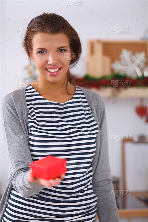 微笑的年轻女人在厨房里，被圣诞背景孤立