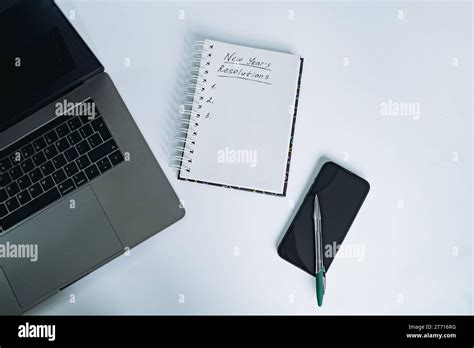 open notepad with resolutions for new 2024 year text near laptop and