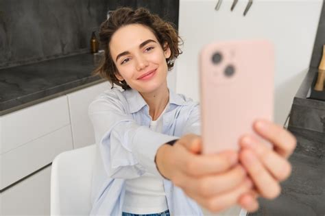 Uma Garota Bonita Tira Selfie O Smartphone Na Cozinha E Tira Fotos Em Casa O Celular