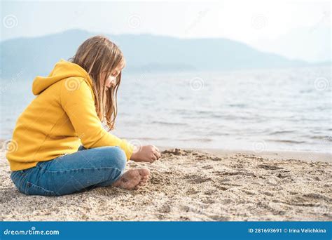 Lonely Beautiful Sad Girl Teenager Sits Thoughtfully On Sand Sea Beach