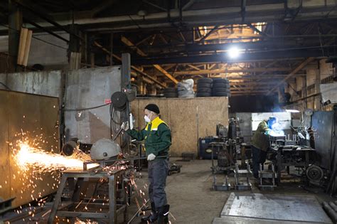 공장에서 금속 건설 작업을 하는 근로자 큰 각도 분쇄기 디스크 톱과 용접 용접 금속 처리 공장에서 금속 가공에 불꽃 그라인드에