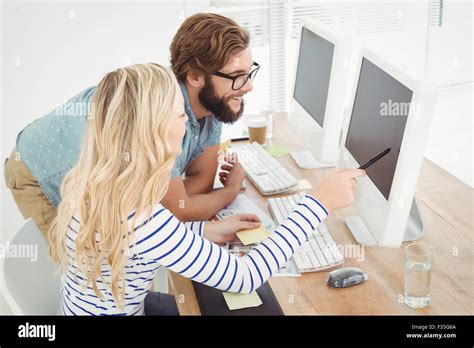 Woman Pointing At Computer With Stylus While Sitting By Man Stock Photo Alamy