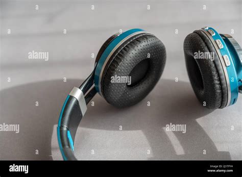 Turquoise And Black Headphones Against A Gray Background Wireless