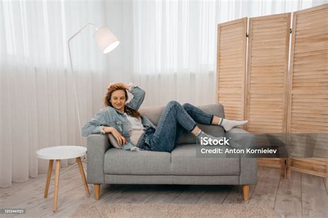 피곤하지만 행복한 어린 학생 소녀 누워 소파 에 집에서 노트북과 머리에 개최 Brand Name Online Messaging