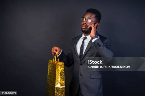 스튜디오에서 검은 배경에 쇼핑백을 들고 있는 아프리카계 미국인 남성 비즈니스 파트너블랙 프라이데이 세일 시즌 컨셉 20 24세에 대한 스톡 사진 및 기타 이미지 Istock