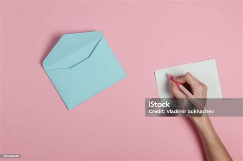여성의 손은 분홍색 파스텔 배경에 펜이 달린 편지를 씁니다 결혼식 초대장 러브 레터 발렌타인 데이 맨 위 보기 러브레터에 대한