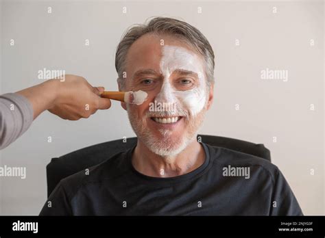 Faceless Female Applying Facial Mask With Brush On Face Of Cheerful