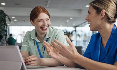 Nmc Revalidation For Nurses Two Nurse Colleagues Laugh Together While