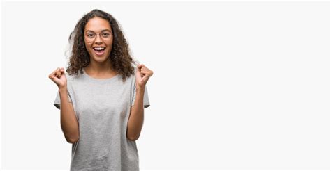 축 하 하는 안경을 쓰고 아름 다운 젊은 히스패닉 여자 놀라게 무기 제기와 성공을 위한 깜짝 놀라게 고 눈을 엽니다 우승자 개념입니다 T 셔츠에 대한 스톡 사진 및 기타