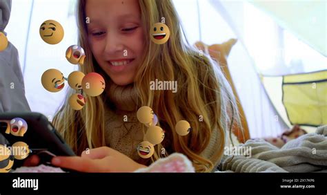 Image Of Multiple Floating Emoticons On Caucasian Girl Using Cellphone