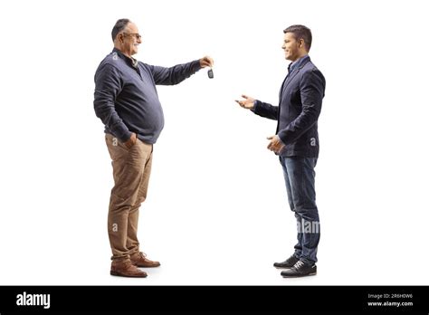 Mature Man Handing Car Keys To A Younger Man Isolated On White