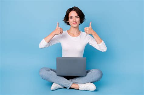 예쁜 귀여운 아가씨 옷을 입은 흰 셔츠 다리 교차 들고 현대 장치 엄지 손가락 위로 고립 된 푸른 색 배경의 사진 25 29세에 대한 스톡 사진 및 기타 이미지 Istock