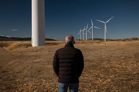 푸른 하늘을 배경으로 현대 풍차와 땅에서 겨울 천에 성인 남자 스페인 카스티야 라 만차에서 촬영 연료 및 전력 생산에 대한 스톡 사진 및 기타 이미지 Istock