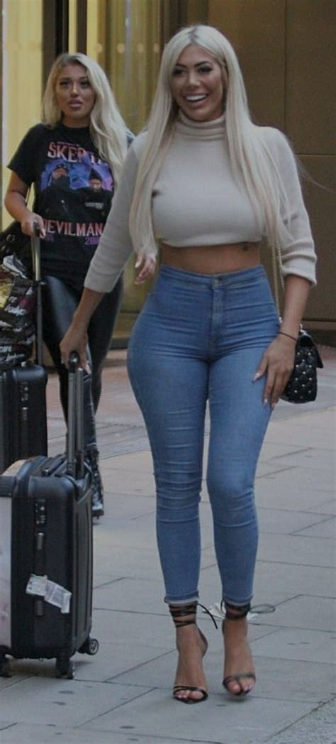 Two Women Are Walking Down The Street With Their Luggage And One Is