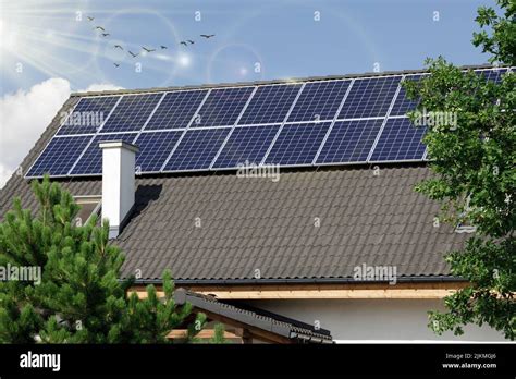 Solar Panels On Rooftop Against Blue Sky And Sun Solar Panels On The