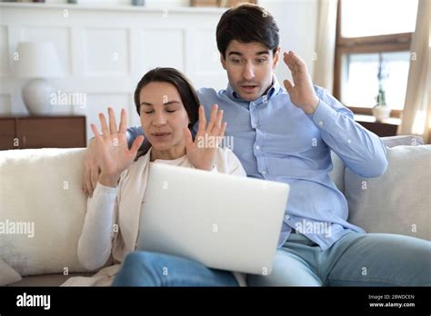 Caucasian Couple Using Laptop Frustrated By Computer Problem Stock