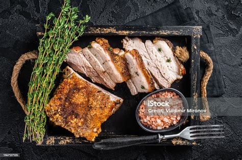 바삭바삭한 로스트 포크 배 향신료가 있는 트레이에 껍질을 얹은 구운 고기를 얇게 썬다 검은 색 배경 위쪽 보기 갈색에 대한 스톡 사진 및 기타 이미지 Istock