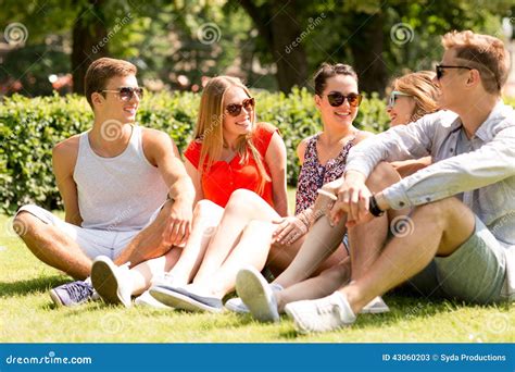 Group Of Smiling Friends Outdoors Sitting On Grass Stock Image Image