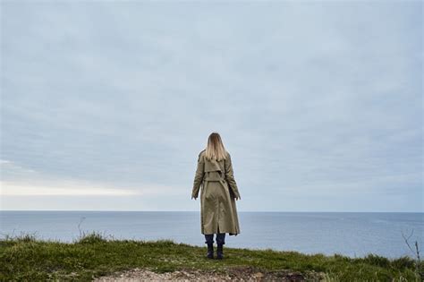 소녀는 절벽 가장자리에 서서 바다 또는 바다를 바라봅니다 여자는 거리를 바라본다 놀라운 경치 자연 보기 아름다운 바위와 바다