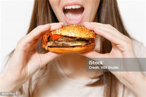 흰색 배경에 고립 먹을 려 고 손에 햄버거에 들고 자른된 샷된 젊은 여자를 닫습니다 적절 한 영양 섭취 또는 고전적인 미국의 패스트 푸드입니다 광고에 대 한 공간을 복사