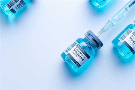 사출 병 보호 독감 바이러스와 코로나 바이러스에 대한 바늘과 의료 주사기 흰색에 고립 된 코비드 백신 바늘이있는 의학 플라스틱