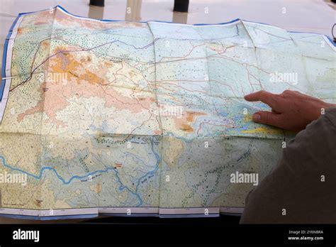 A Person Points At A Detailed Topographic Map Aiding In Navigation And Exploration The Map