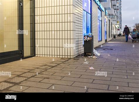 Garbage Bins In The Yard An Overflowing Urn Near The Entrance Of An Apartment Building Stock