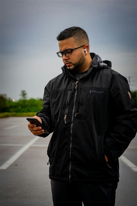 Foto Hombre Con Chaqueta De Cuero Negro Sosteniendo Un Teléfono