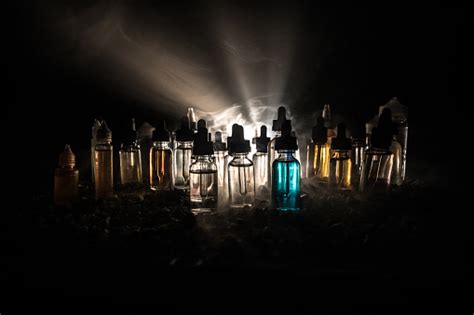 Vape 개념입니다 어두운 배경에 연기 구름과 Vape 액체 병 조명 효과 배경 또는 전자 담배 광고로 유용 합니다 0명에 대한