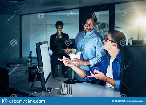 Discussing The Work At Hand A Group Of Programmers Working Together On A Computer In The Office