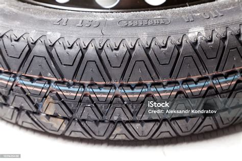 사진 스튜디오에서 흰색 배경에 트레드에 파란색과 빨간색 줄무늬가있는 자동차 예비 휠을 클로즈업 자동차 서비스에서 계절 자동차