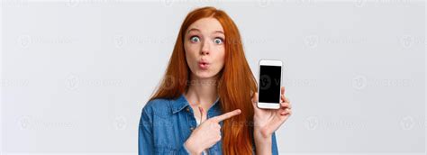 Curious And Amused Lovely Redhead Woman With Long Red Hair Folding Lips Intrigued And Excited