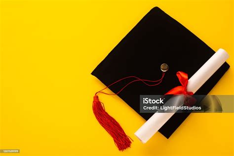 노란색 배경위에 졸업장이 있는 빨간 술이 있는 검은 색 졸업 모자의 탑 뷰 학사모에 대한 스톡 사진 및 기타 이미지 학사모 스튜디오 촬영 졸업식 Istock