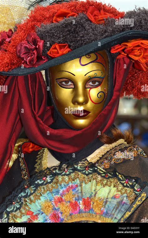 Woman With Gold Mask And Dark Red Costume At The Carnival In Venice