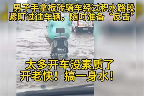 男子手拿板砖骑车经过积水路段紧盯过往车辆随时准备出击