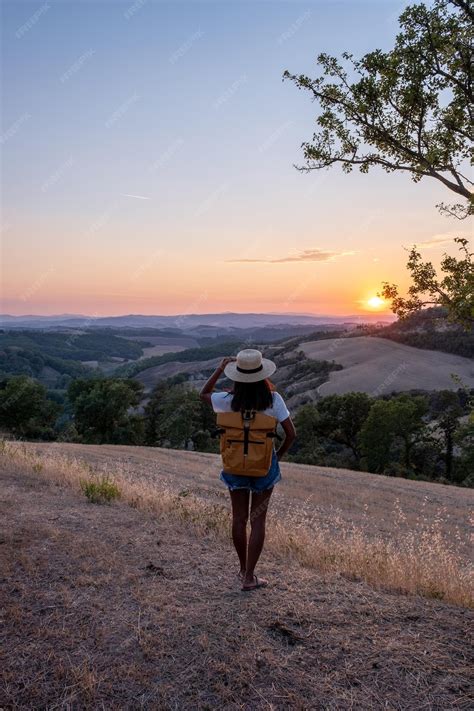 Premium Photo Rear View Of Woman Standing On Landscape During Sunset
