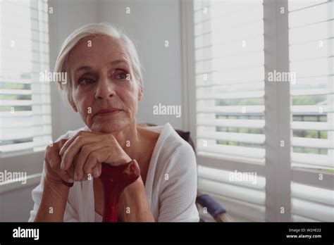 Active Senior Woman Leaning On Walking Cane And Looking Away In A