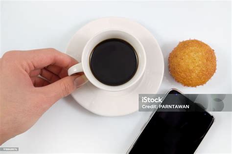 보기 톱 손 브라 우 니 머핀 케이크와 스마트폰 흰색 배경 부드러운 톤 빈티지 배경에서 개념에서 커피 브레이크에 고립 된 흰색