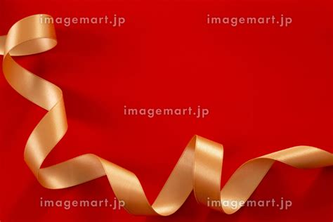 赤い無地の背景と金色のリボンのプレゼントのイメージの写真素材 181321790 イメージマート