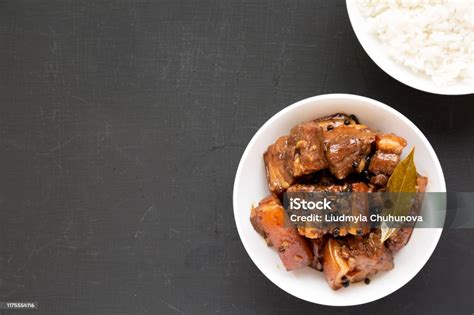 검은 나무 표면에 쌀과 수제 필리핀 아도보 돼지 고기 상단 보기 평면 누워 오버 헤드 위에서 텍스트의 공백입니다 음식에 대한