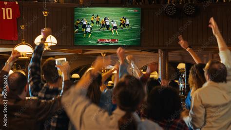 Group Of American Football Fans Watching A Live Match Broadcast In A