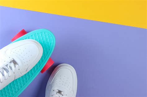 플라스틱 미니 크루저 보드에 흰색 운동화 파스텔 색상 배경입니다 맨 위 보기 개념에 대한 스톡 사진 및 기타 이미지 개념