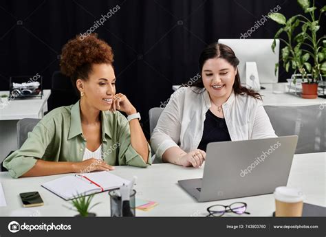 Two Stylish Businesswomen Engage Dynamic Discussion While Reviewing