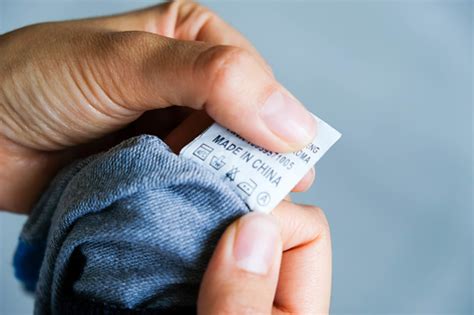 케어 라벨을 확인 하는 여자 선택적 초점입니다 여자의 손 들고 지침을 청소와 옷 레이블 업의 사람 읽기는 의류 라벨 보여주는
