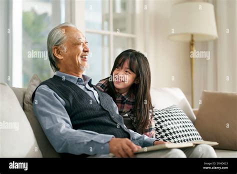 Asian Grandpa And Granddaughter Having A Good Time In Living At Home