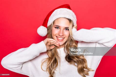 빨간 배경에 고립 된 산타 모자에 따뜻한 옷을 입고 젊은 예쁜 여자 겨울에 대한 스톡 사진 및 기타 이미지 겨울 놀라움