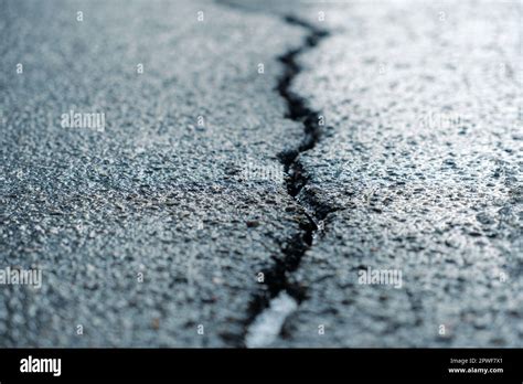 A Crack In The Asphalt Divides The Asphalt Into Two Halves Crack In Wet Asphalt Pavement Stock