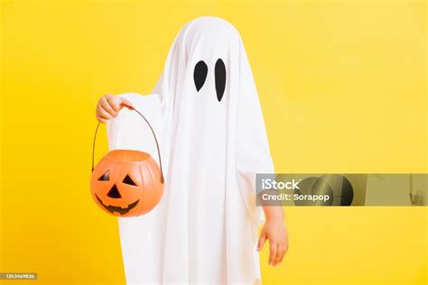 흰색 옷을 입은 의상 할로윈 유령 무서운 작은 귀여운 아이는 손에 오렌지 호박 유령을 들고 2 3 살에 대한 스톡 사진 및 기타
