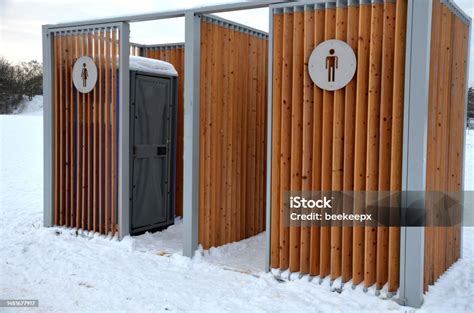 화학 화장실을 배치하기위한 폐쇄 케이지 보기 흉한 플라스틱 상자는 평평한 지붕과 벽에 나무 칸막이가있는 금속 집 안에 있습니다